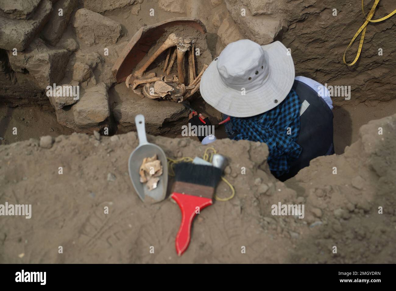 In this Feb. 12, 2020 photo, an archaeologist handles ancient bones and ...