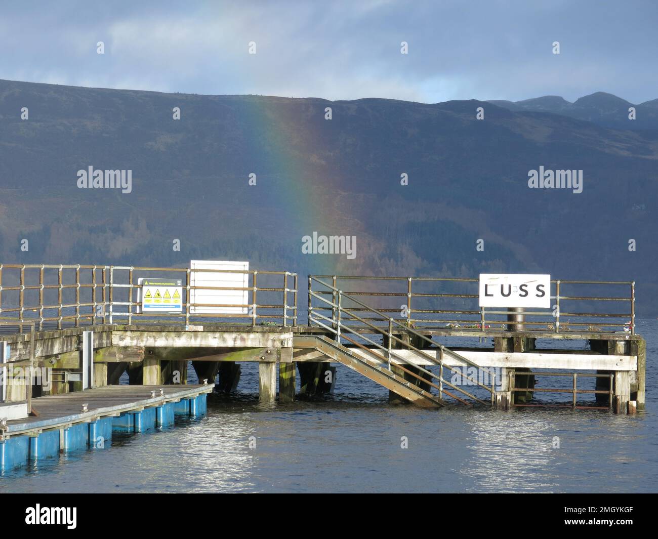 A rainbow shines in the winter sunlight at the end of the pier at Luss ...
