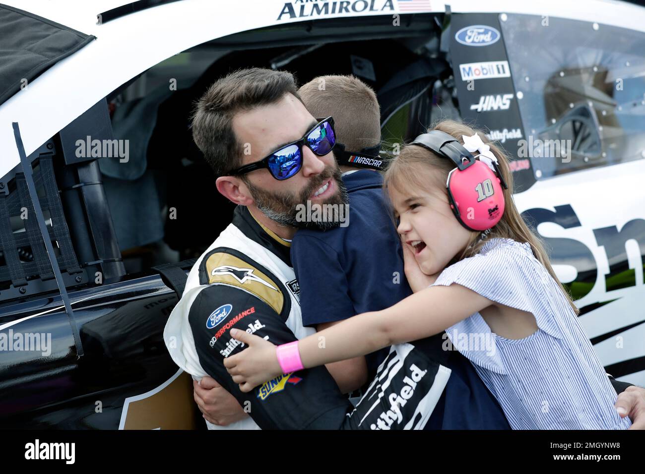 Aric Almirola, left, hugs his children Alex, center, and Abby, right ...