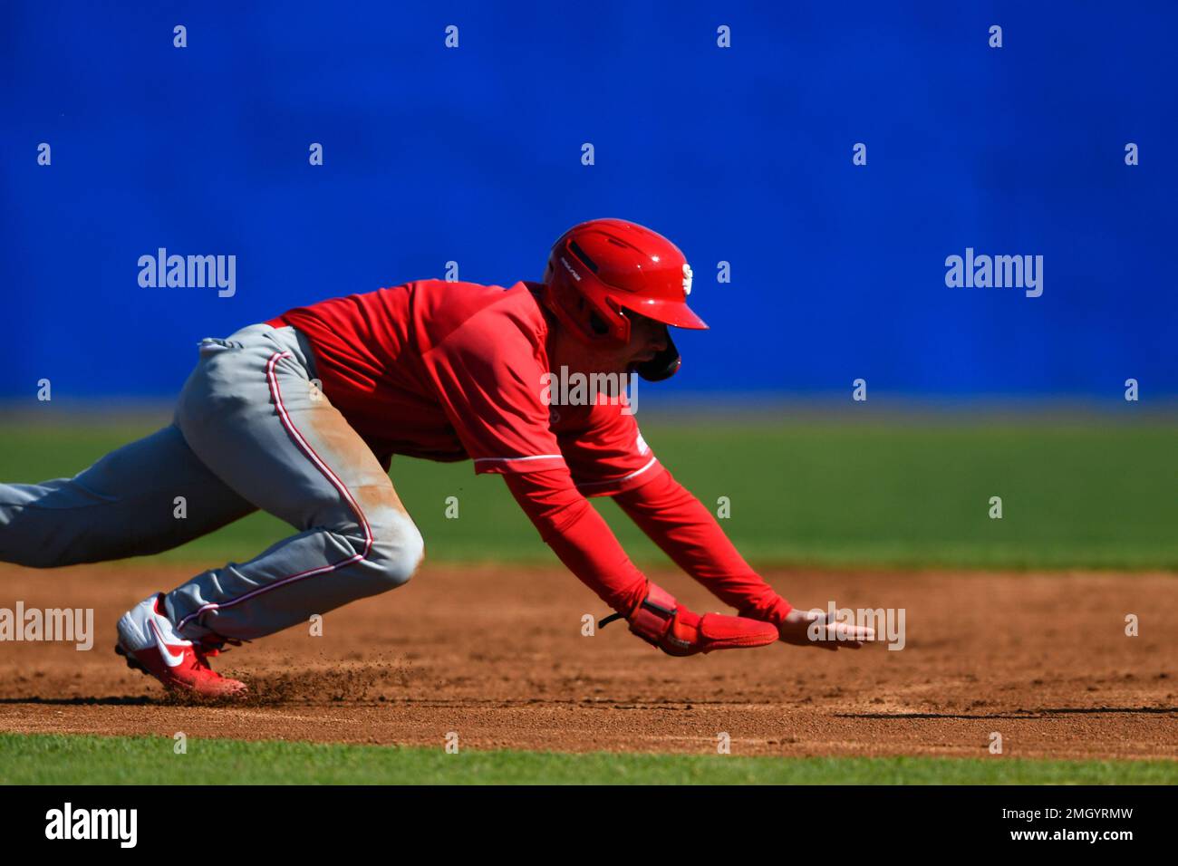Saint John's player Carson Bartels dives back to first base during an ...