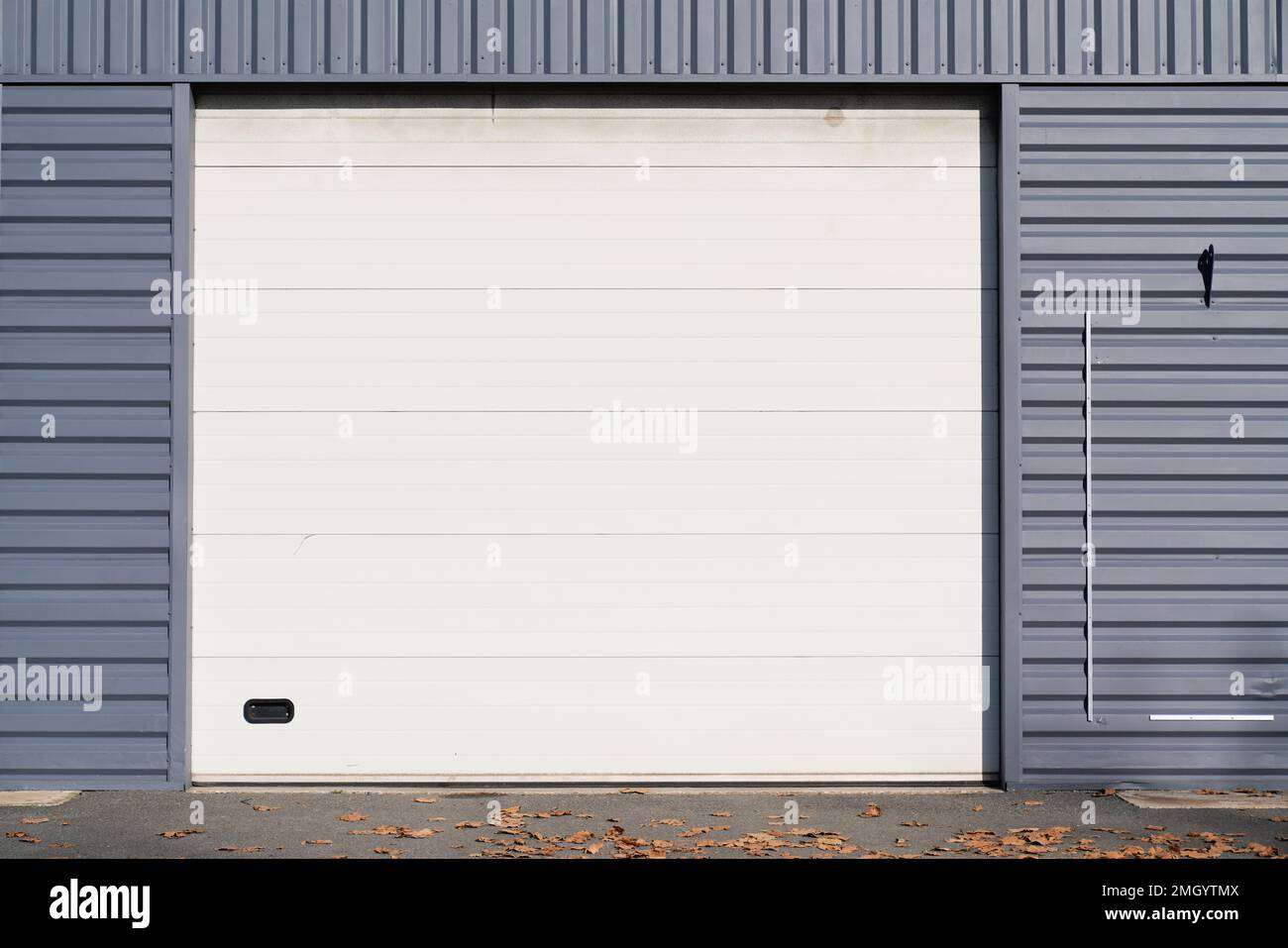 Industrial gray Unit facade of storehouse with closed white metal gate ...