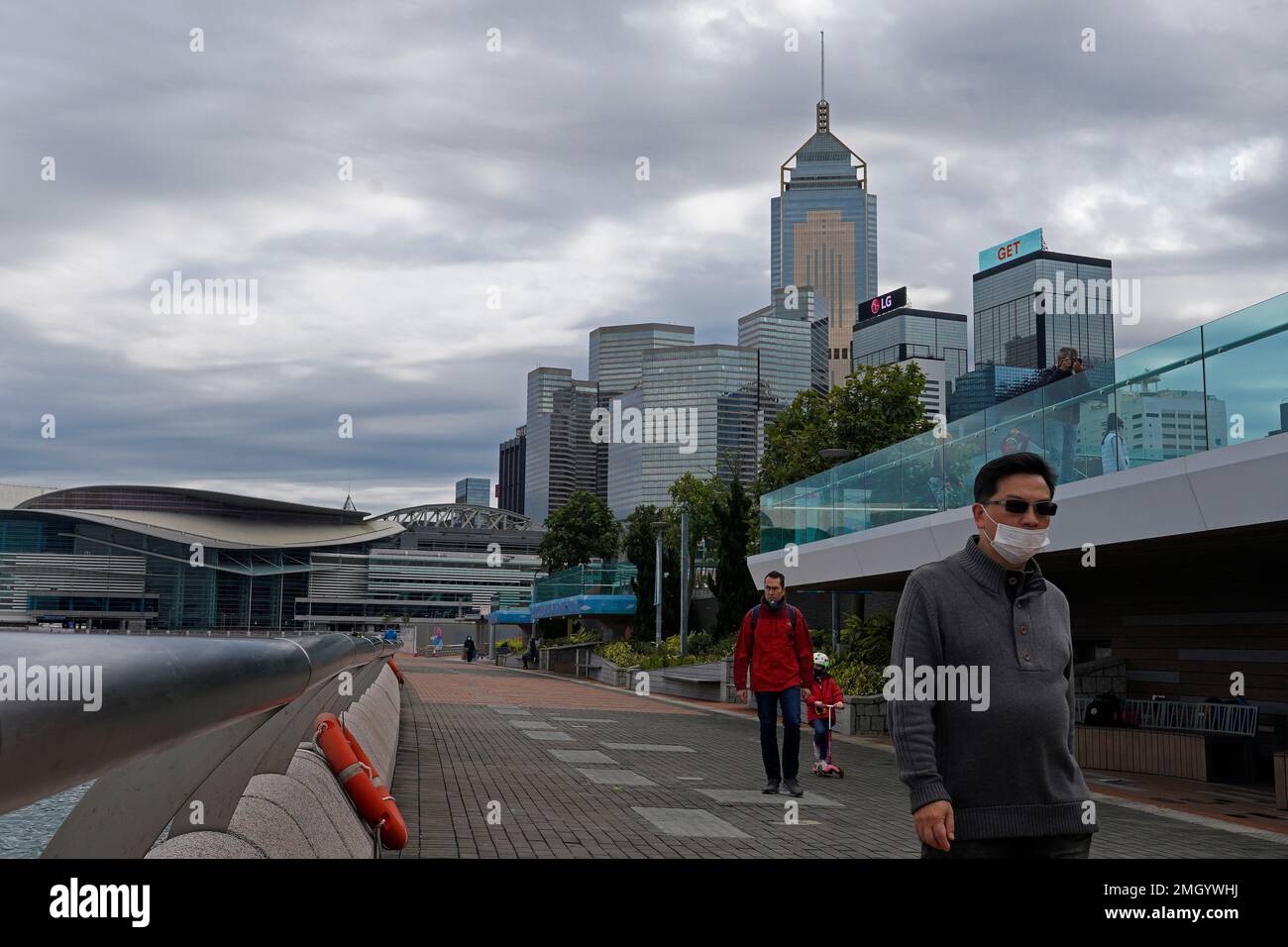 A man wearing a face mask walks at the waterfront in Hong Kong Sunday ...