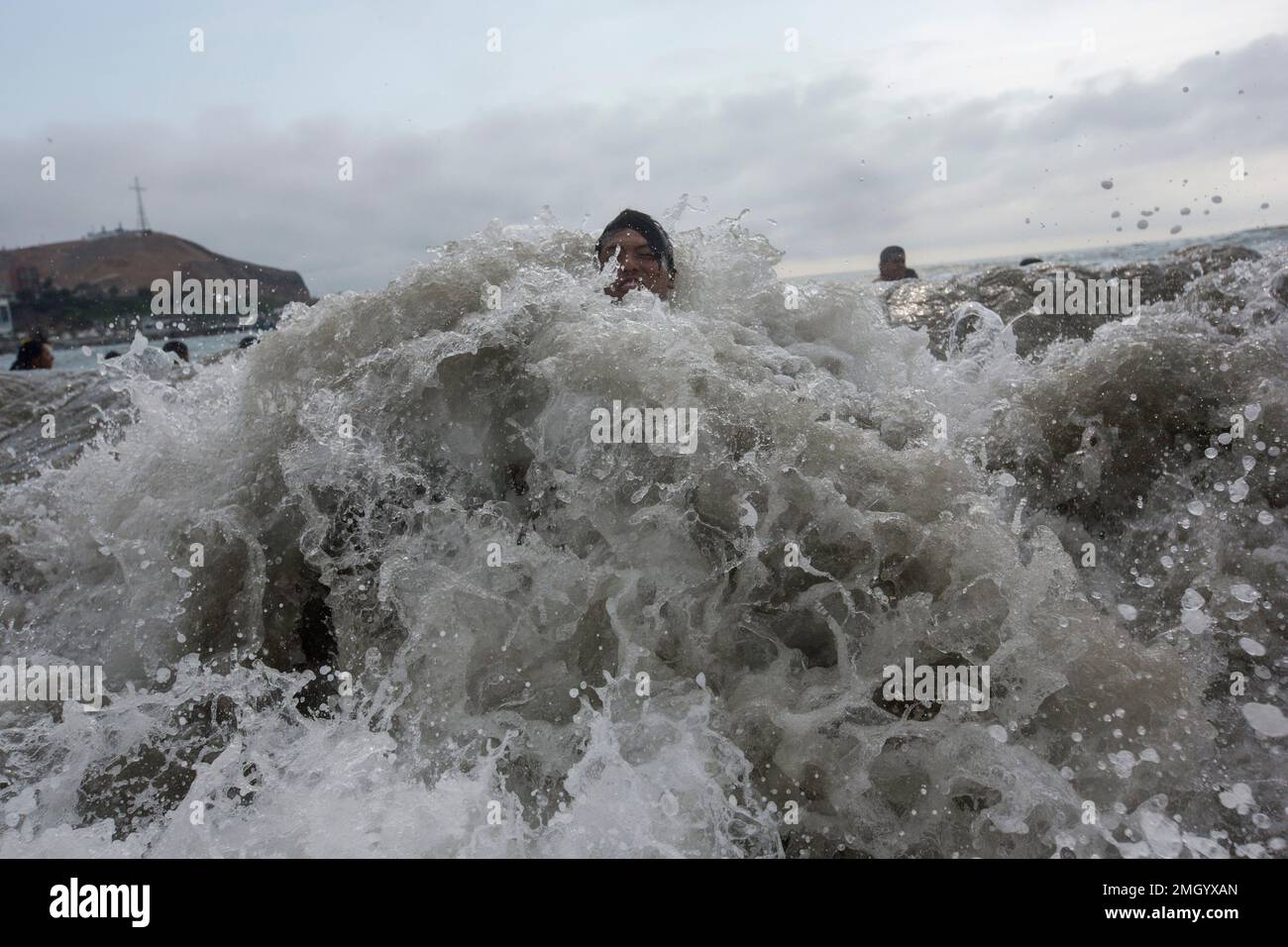 A wave washes over a bather in the Pacific Ocean at Agua Dulce beach ...