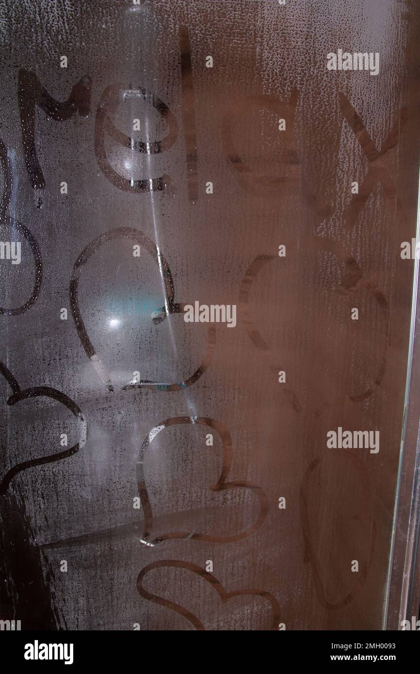 photo drawing of hearts on the fogged glass door in the shower cubicle ...
