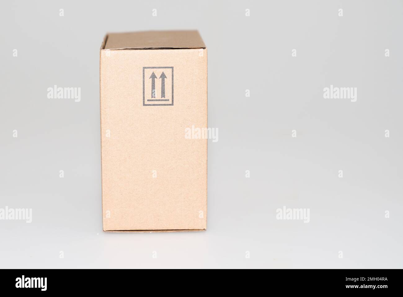 real brown tall cardboard closed box with arrow side up Stock Photo - Alamy