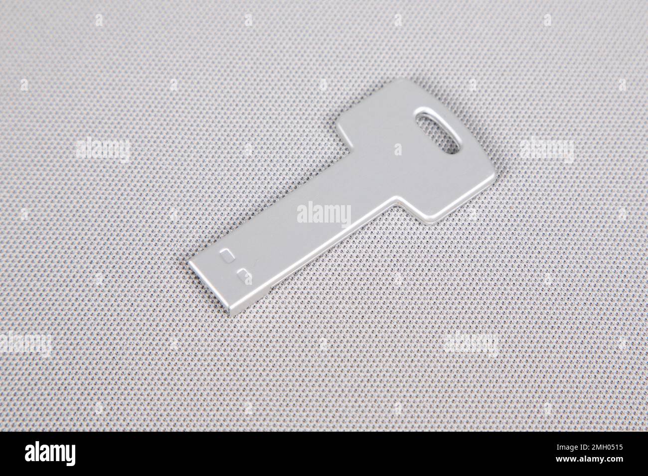metal silver key USB flash drive ready to connected on white desk grey ...
