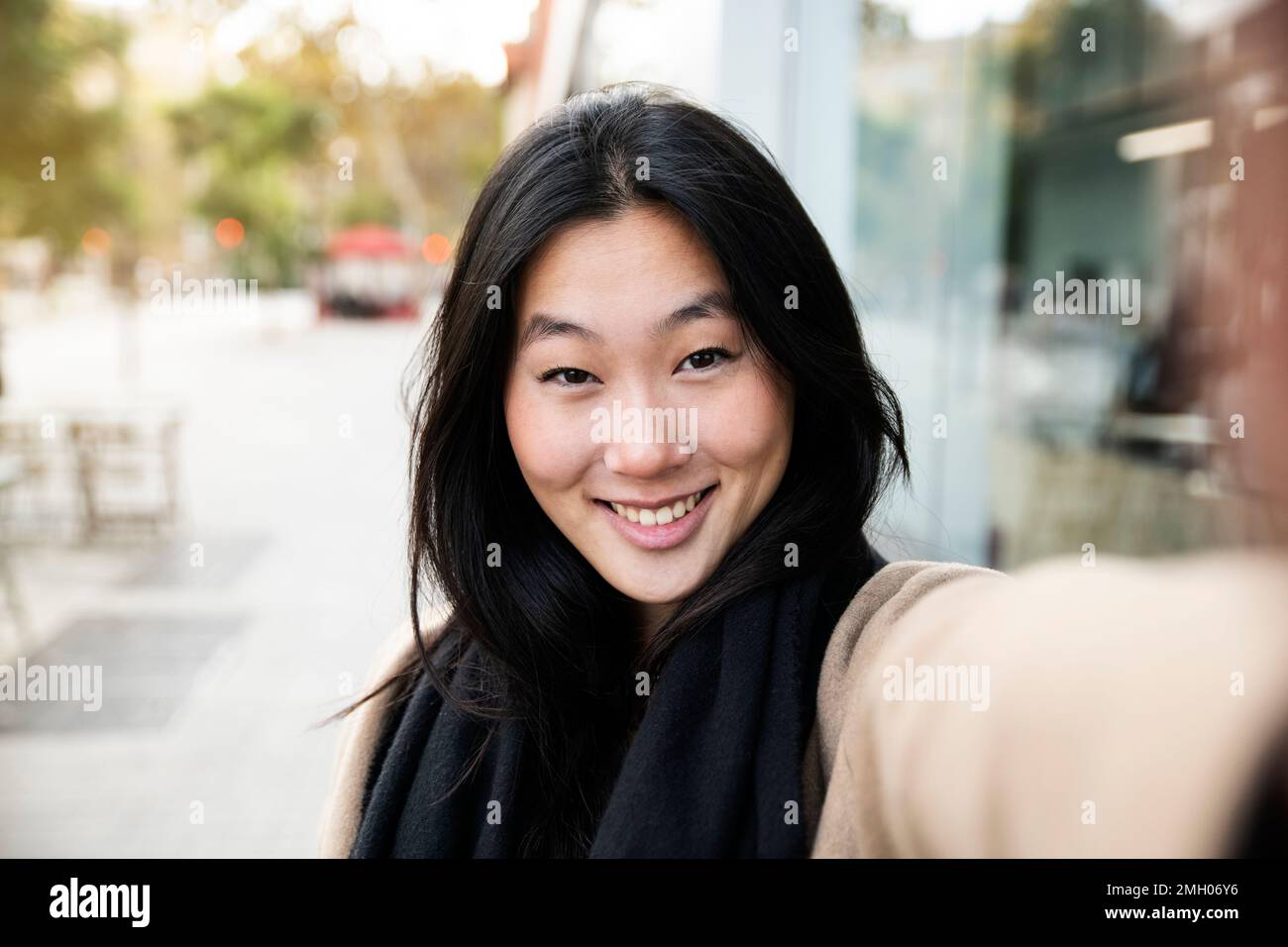 happy young smiling woman taking a self portrait photo in the city ...