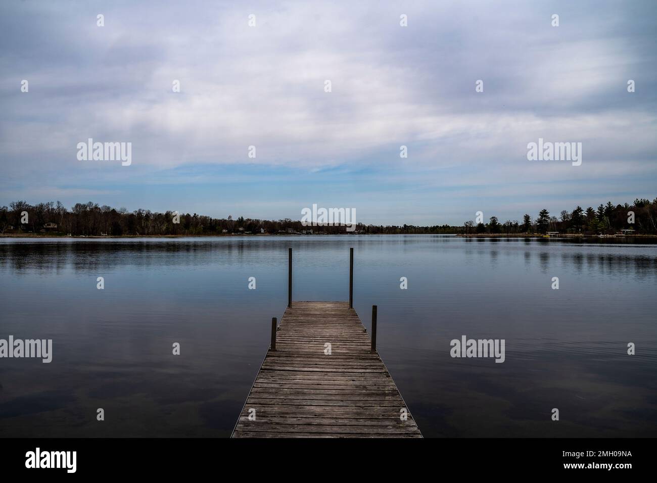 Wood Dock On Calm Lake on Cloudy Spring Day Stock Photo - Alamy