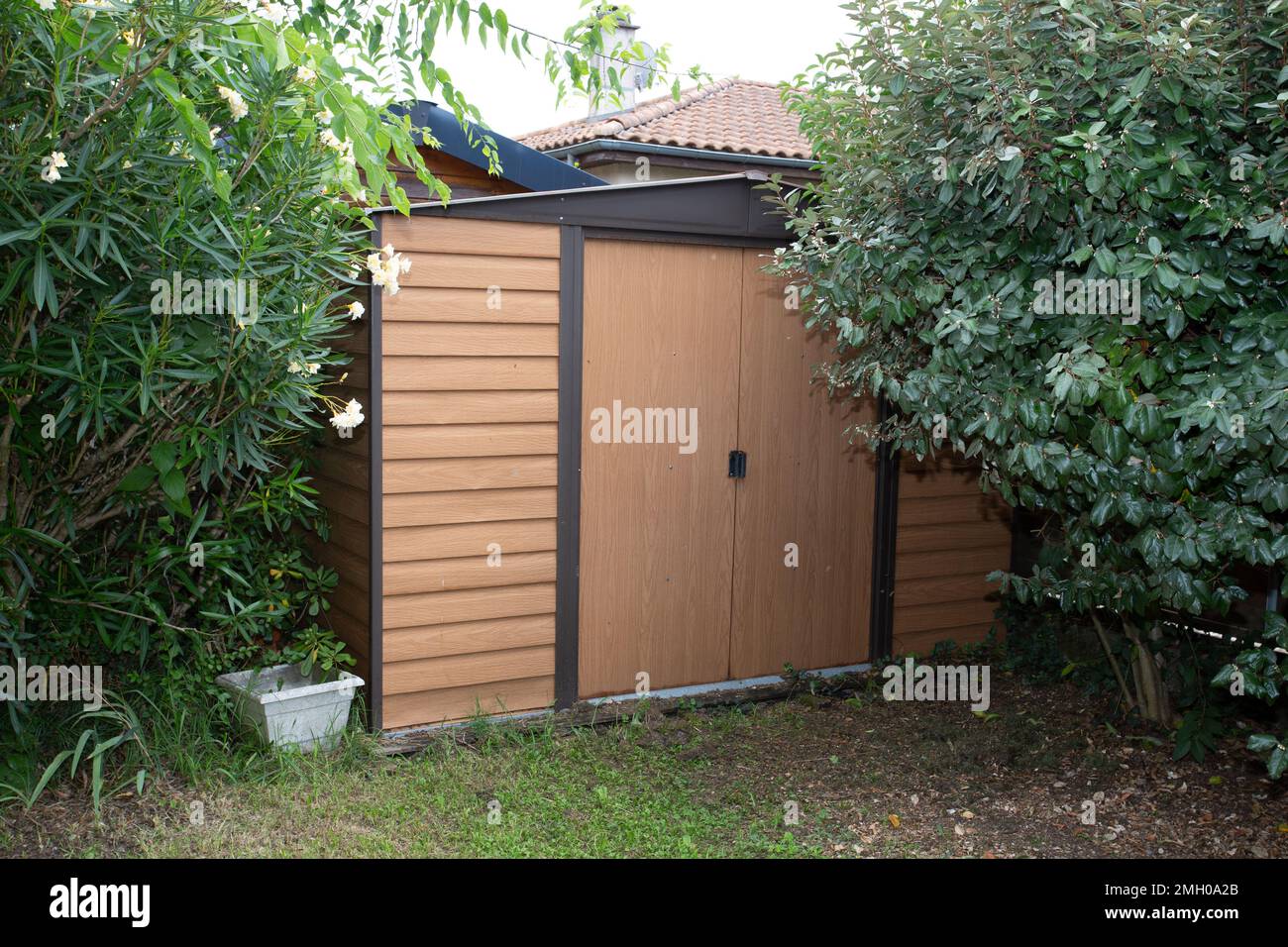 home garden storage shed in the house backyard on green trees ...