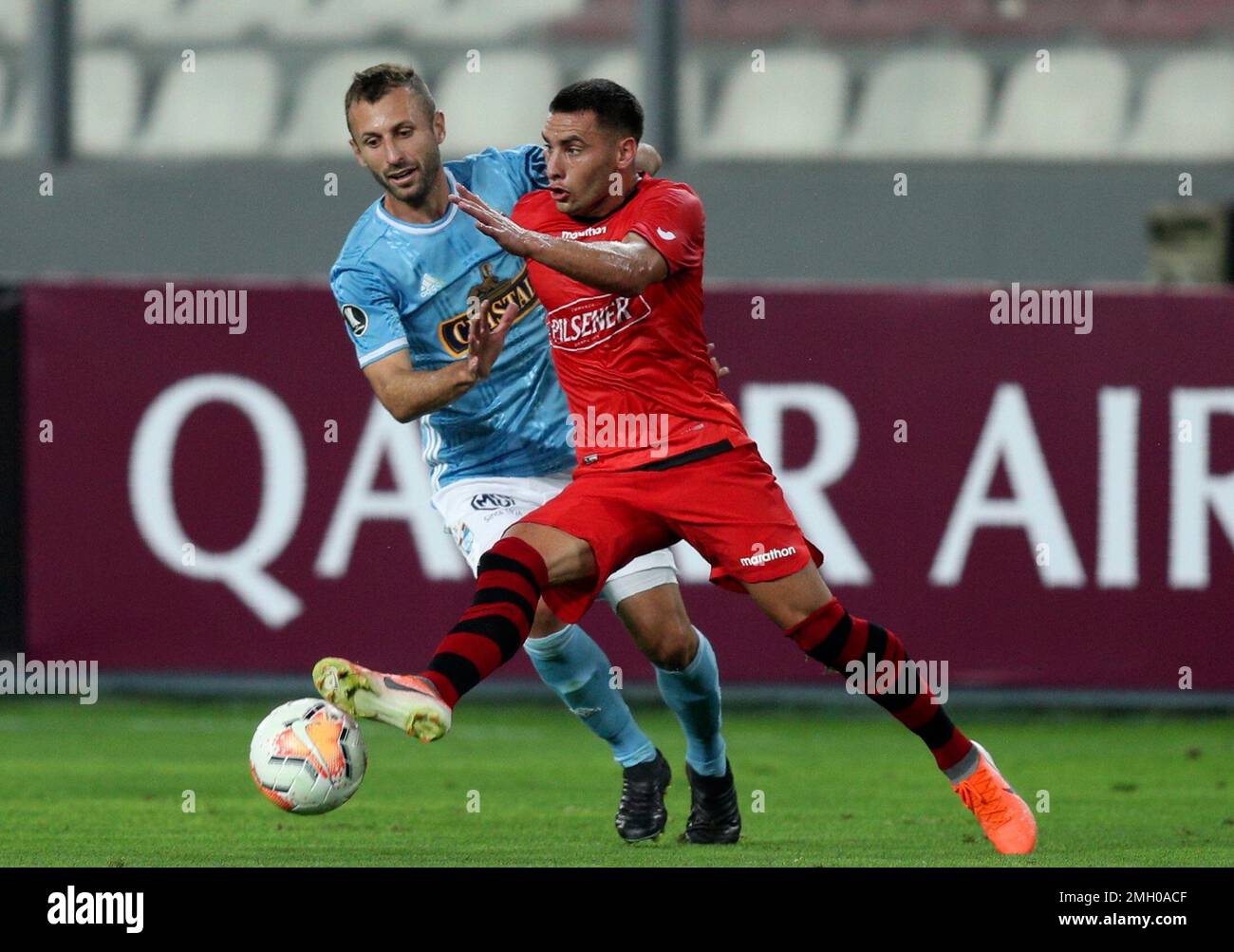 Leandro Martine, front, of Ecuador's Barcelona fights for the ball with ...