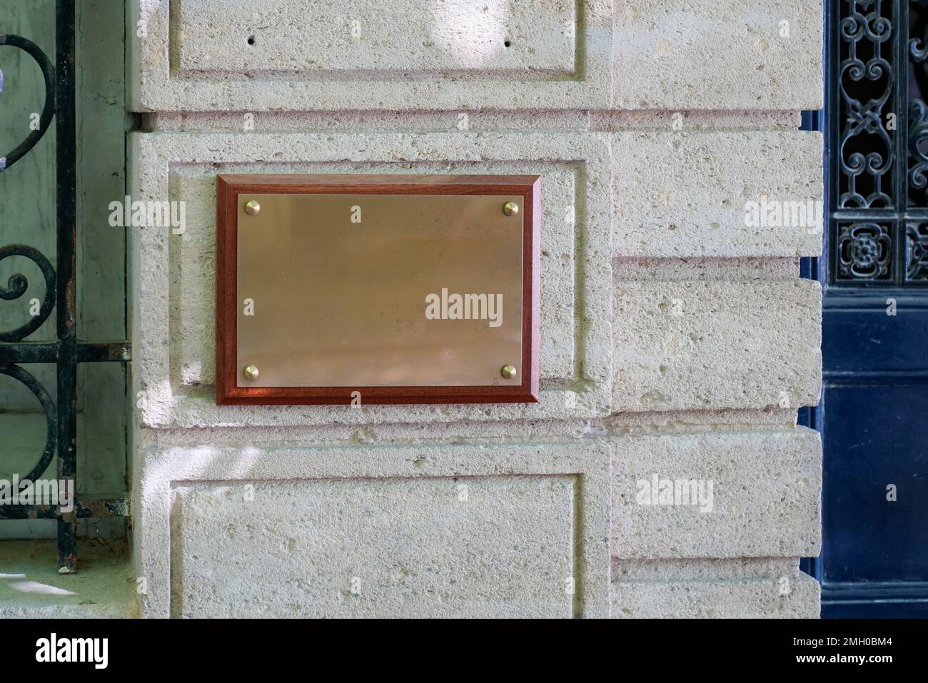 empty copper blank plate on the entrance signboard on textured wall ...