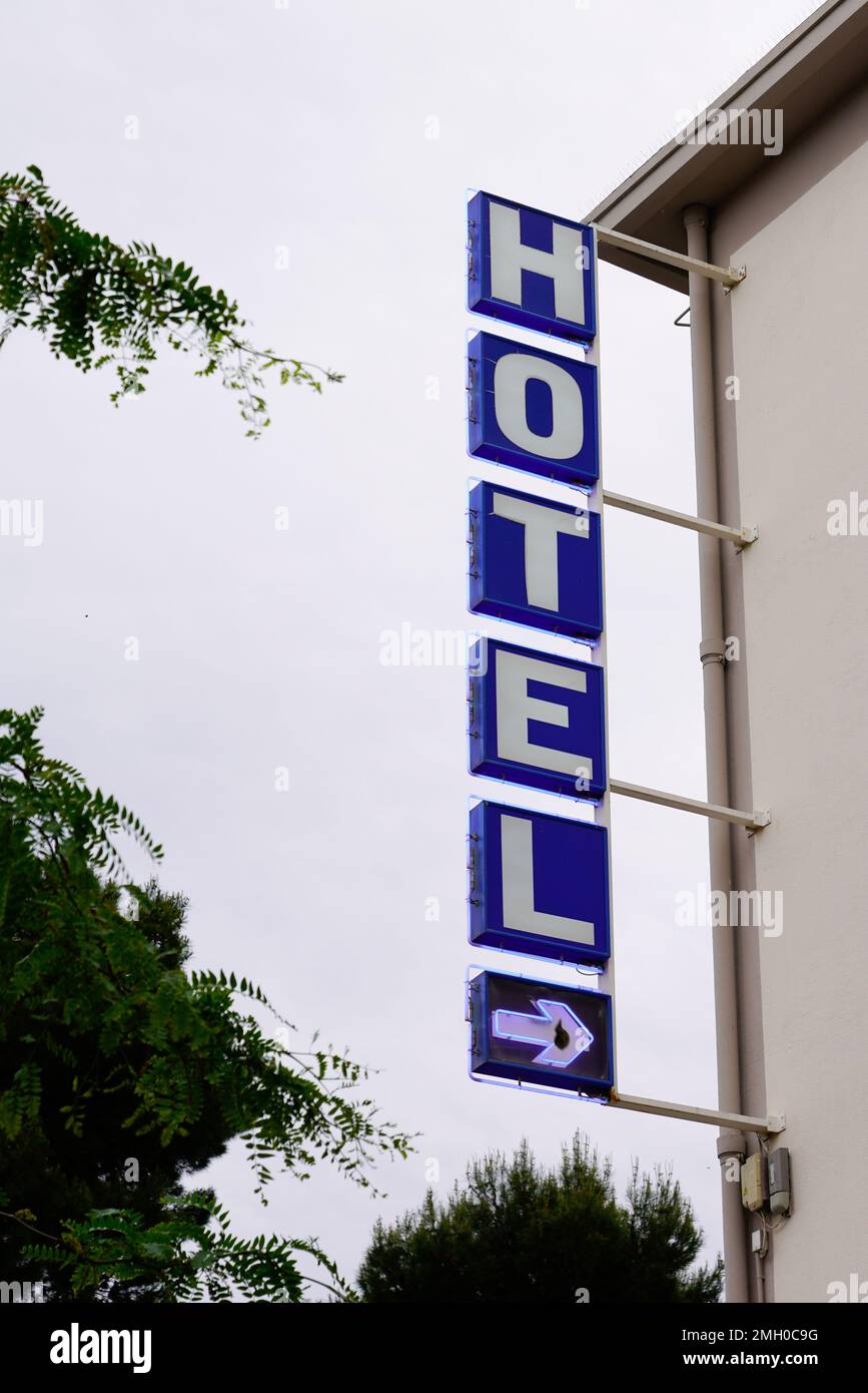 Hotel sign text blue and arrow in wall building facade in french ...