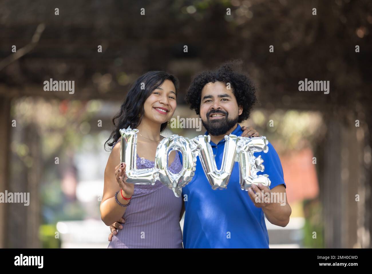 Mexican young couple holding love balloon Stock Photo - Alamy