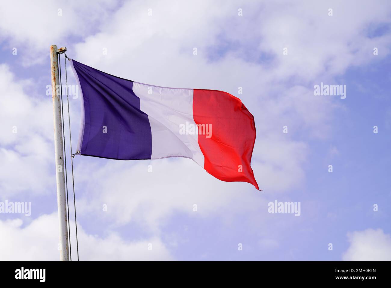 French flag of France wave over a blue cloud sky Stock Photo - Alamy