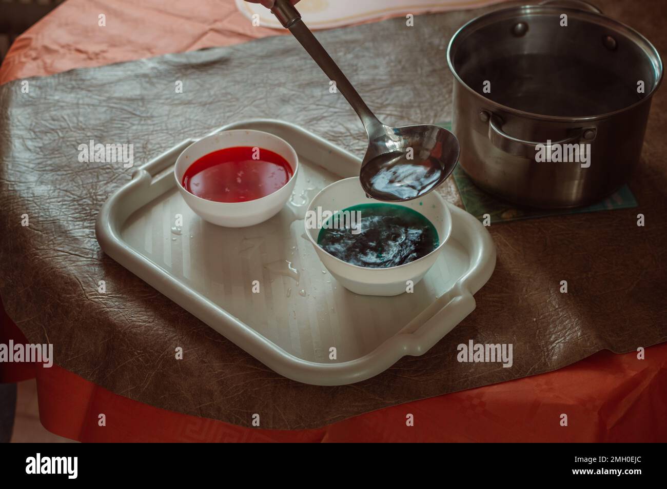 Pouring liquid paints for coloring Easter eggs Stock Photo - Alamy