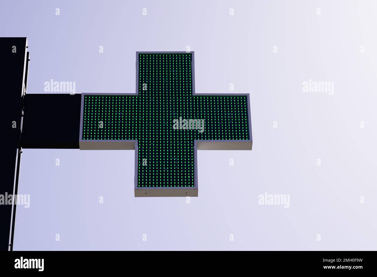 green cross lighting sign on wall building of pharmacy Stock Photo - Alamy