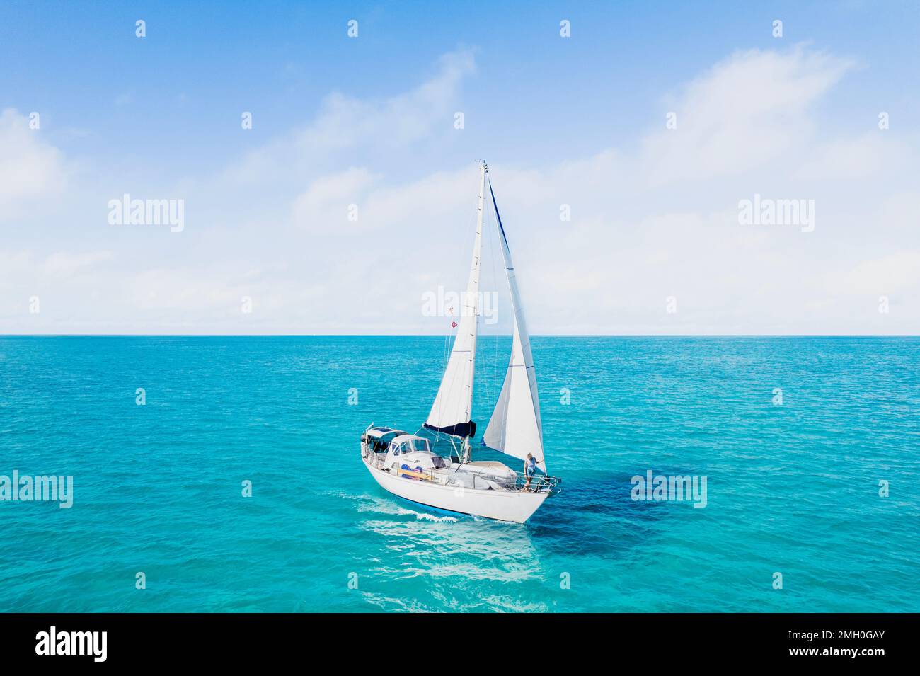 Sailboat Sailing Through Turquoise Bahamas Waters with Woman on Bow ...
