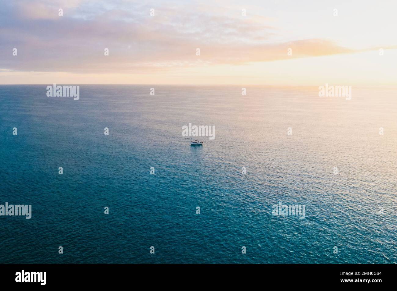 Aerial of Sailboat in Flat Calm Seas Anchored in the Bahamas at Sunset ...