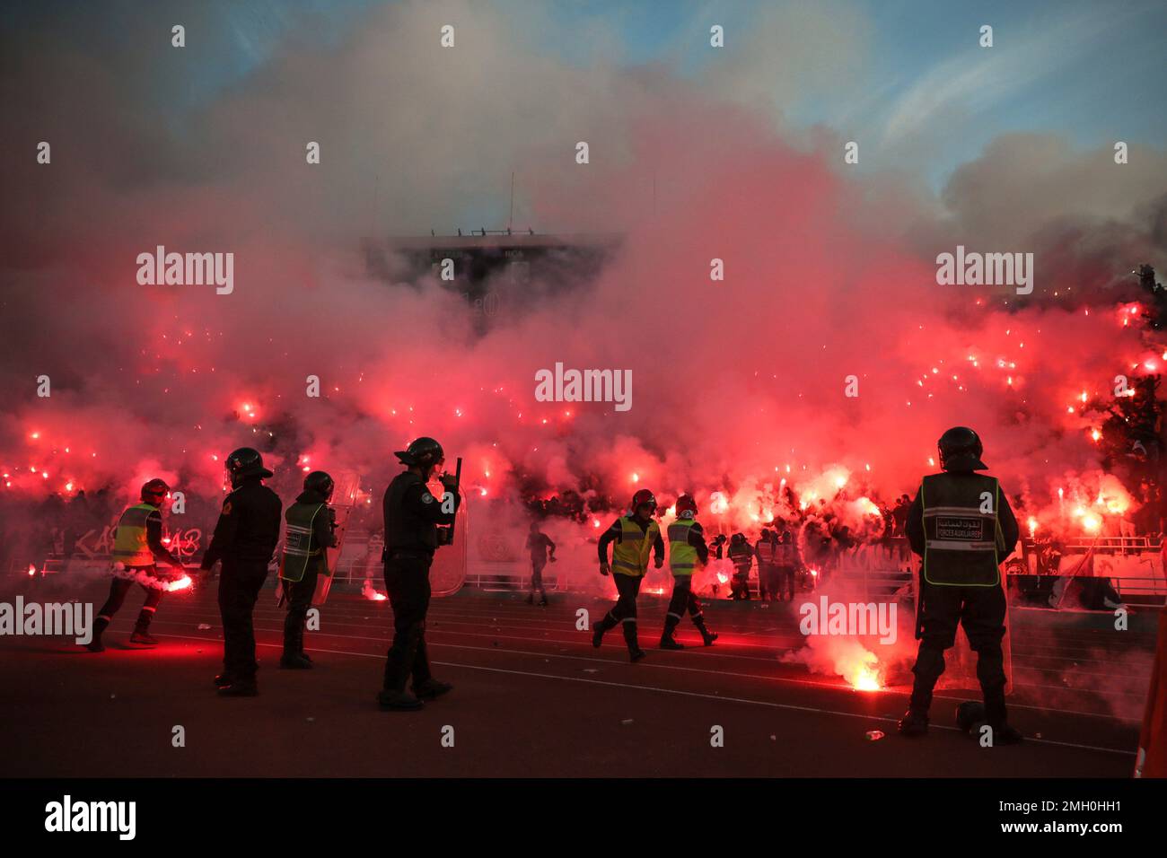 Security forces stand guard as fans of FAR Rabat soccer team light ...