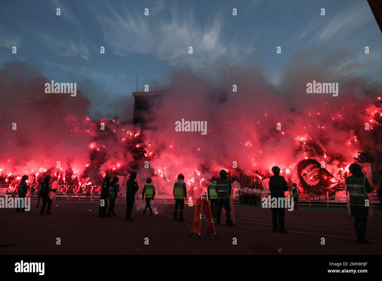 Security forces stand guard as fans of FAR Rabat soccer team light ...