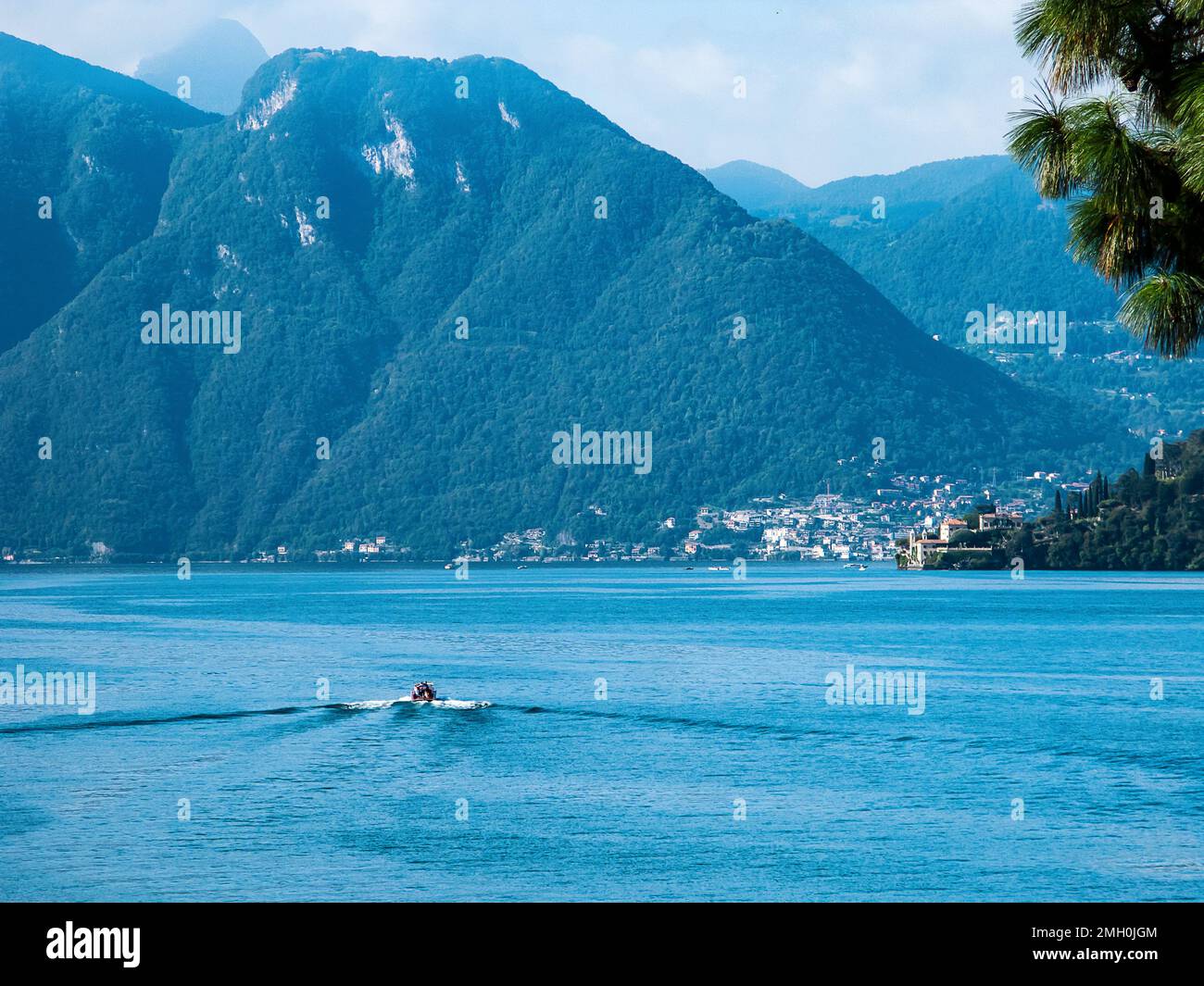 view of Lake Como, mountains, blue sky with white clouds and boat ...