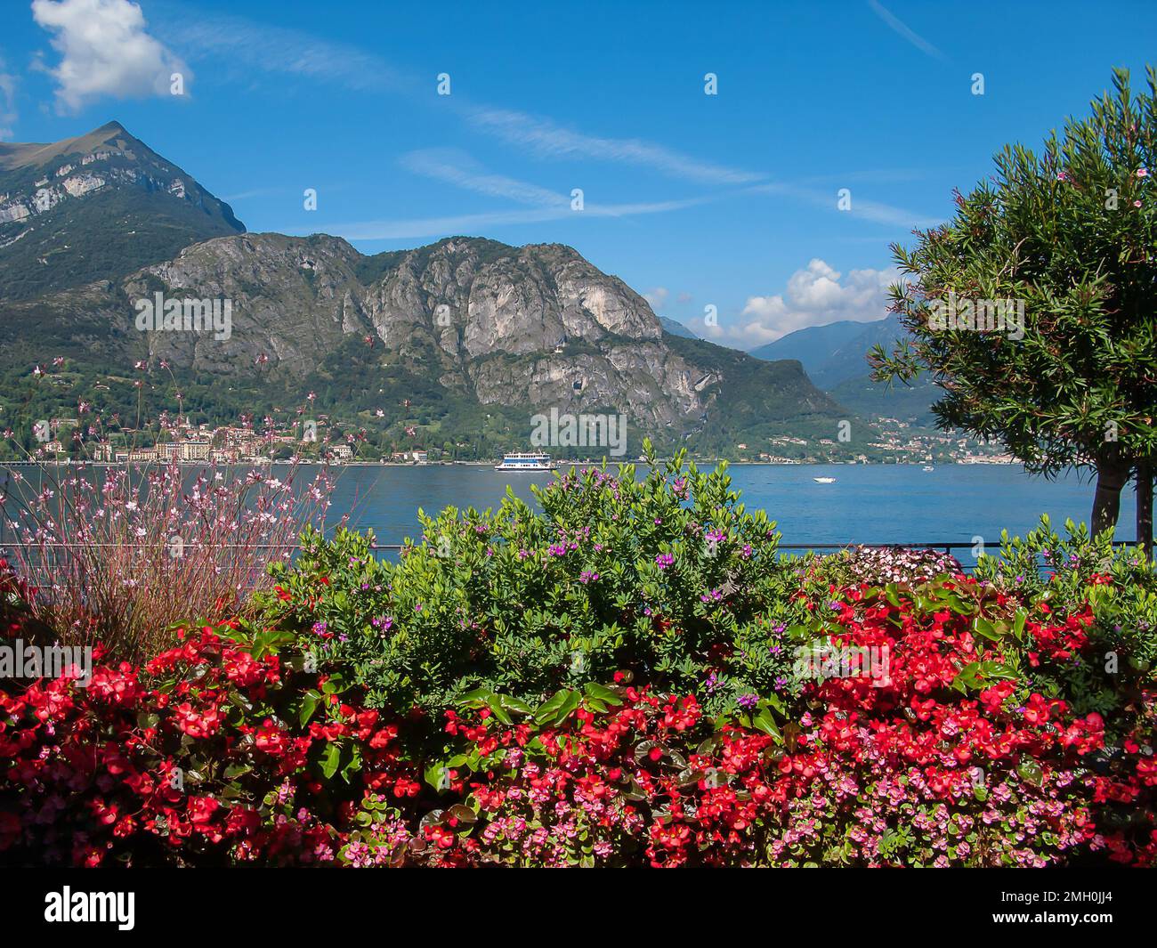 view of Lake Como, mountains and blue sky from the seafront of the ...