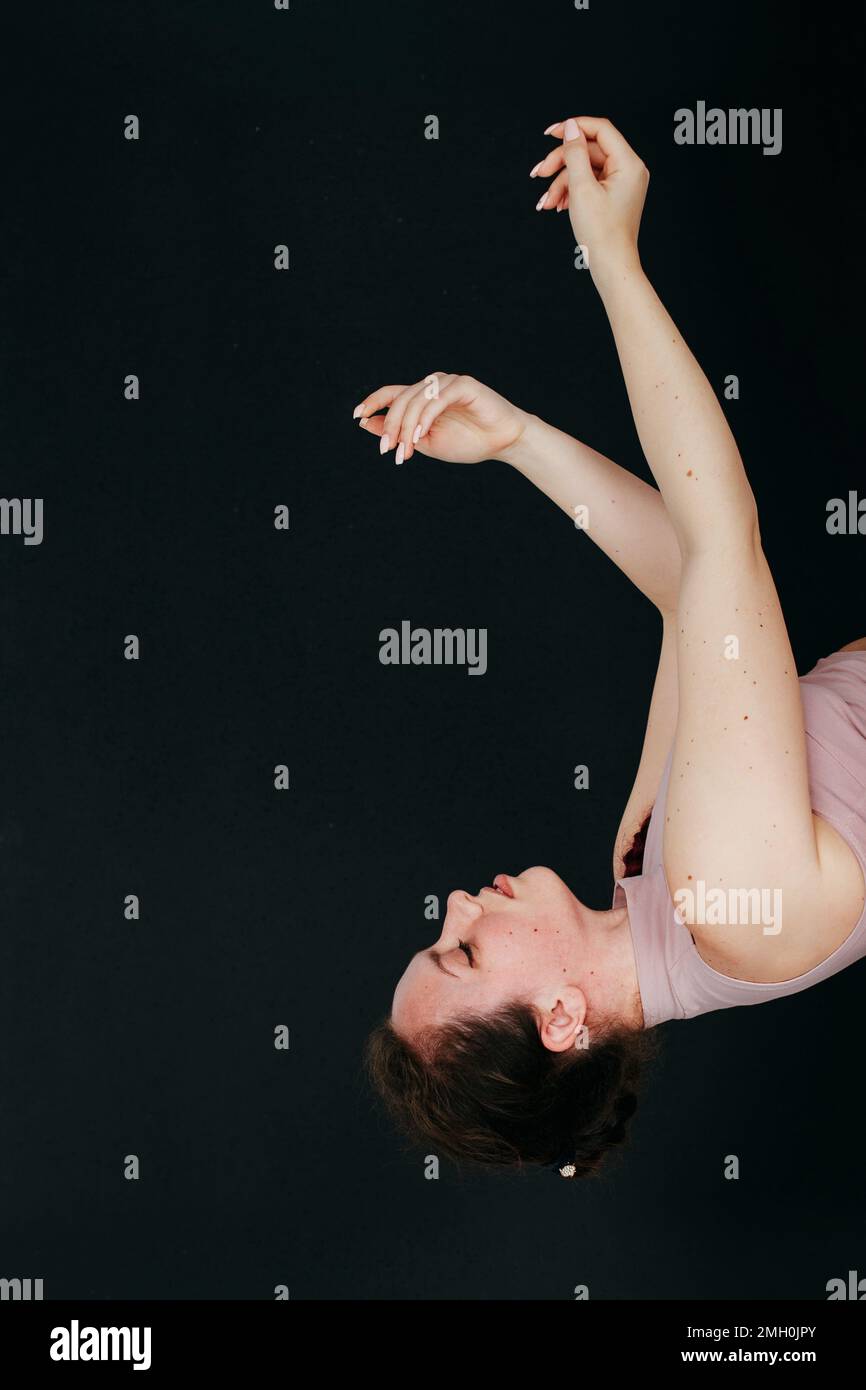 Close up studio portrait of a young brunette female gymnast makes ...