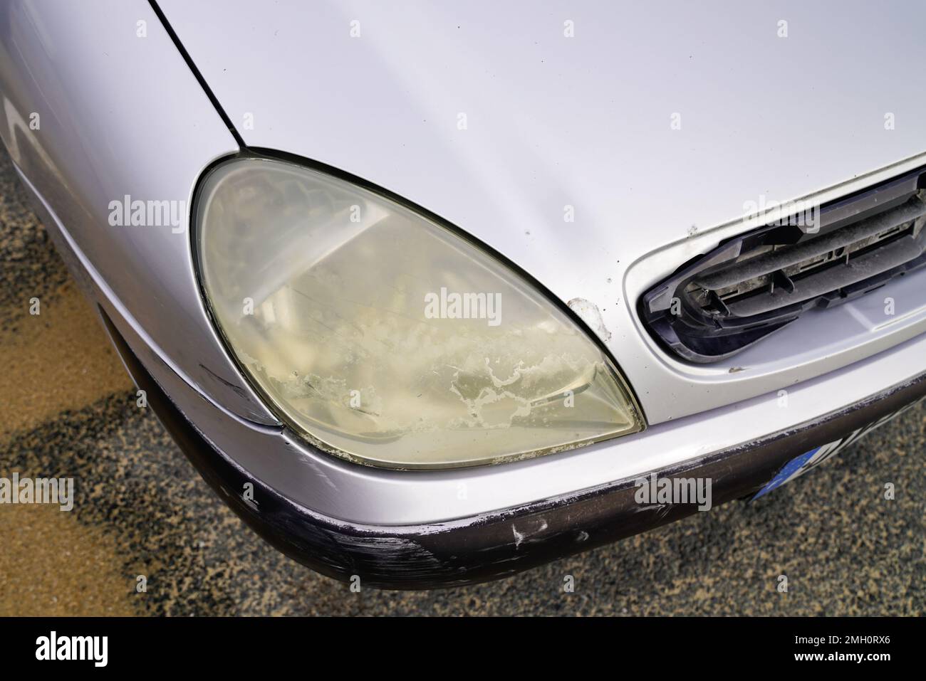Close up hazy yellowed dirty car unpolished cloudy foggy front plastic ...