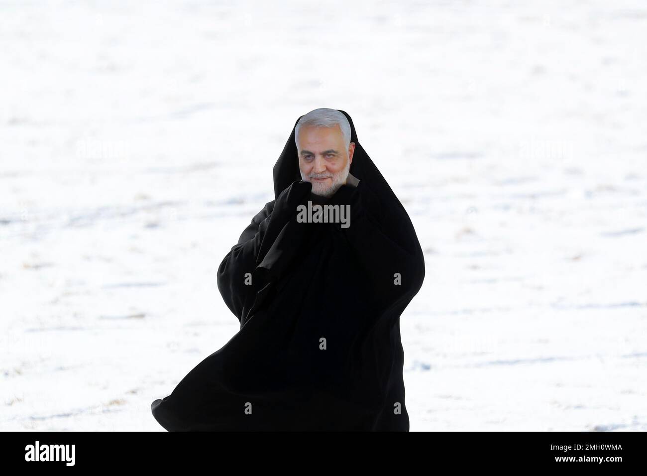 An Iranian holds up a picture of Gen. Qassem Soleimani during a rally ...