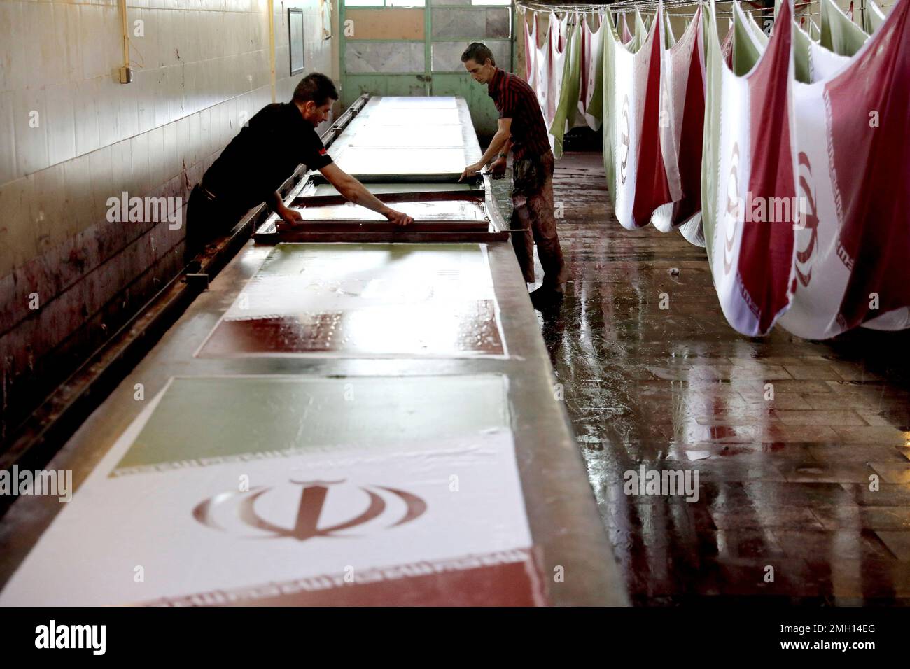 In this Saturday, Feb. 8, 2020 photo, workers use a silk screen to ...