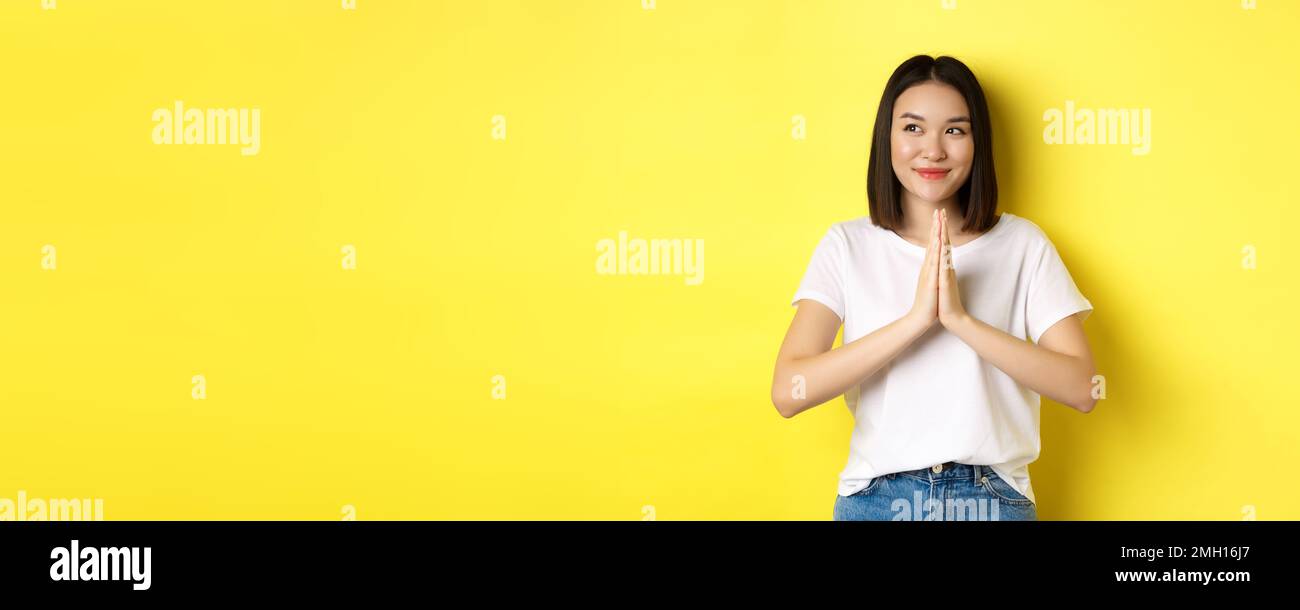 Pretty Asian Woman Holding Hands In Namaste Pray Gesture Looking Left