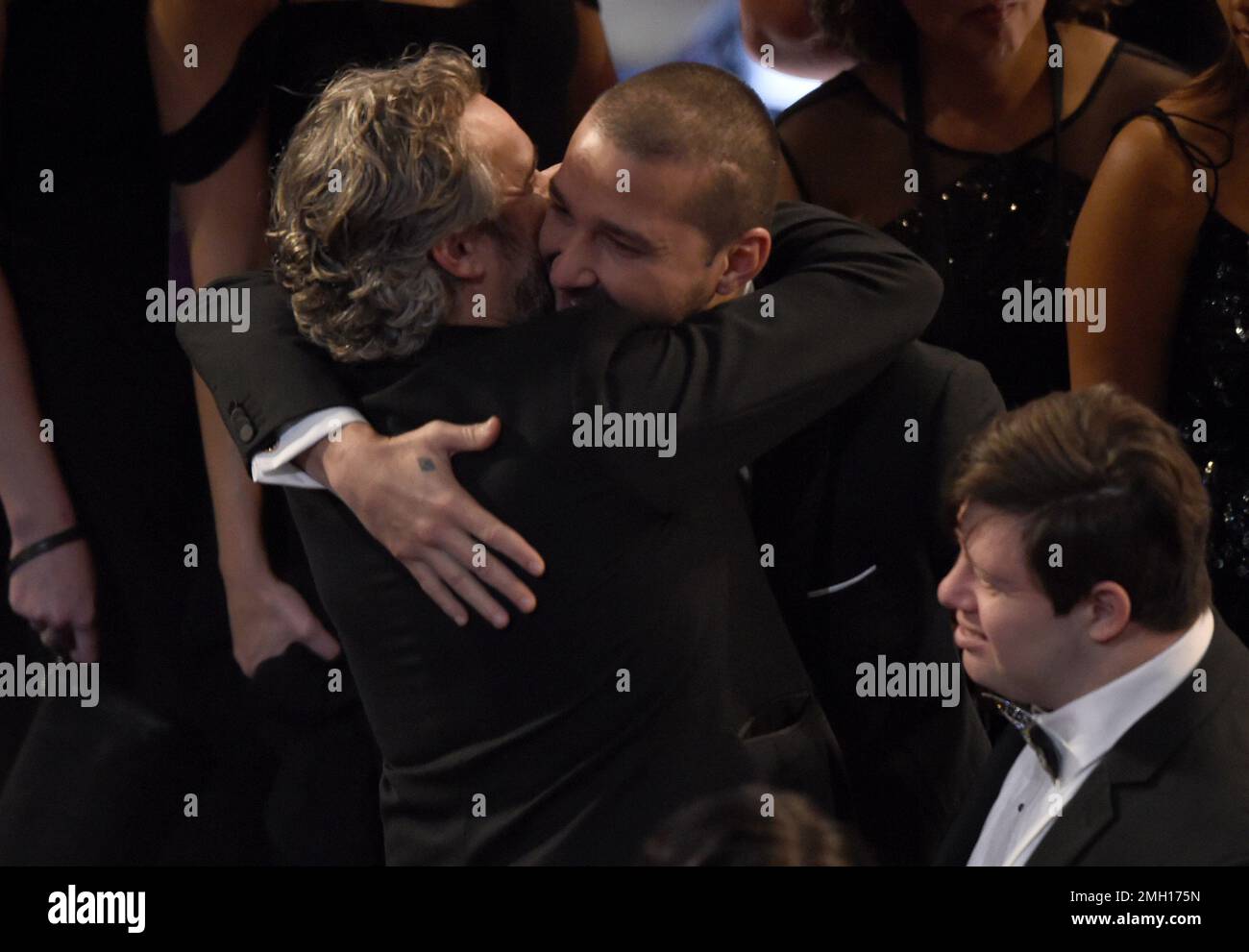 Joaquin Phoenix, from left, hugs Shia LaBeouf in the audience, as Zack ...