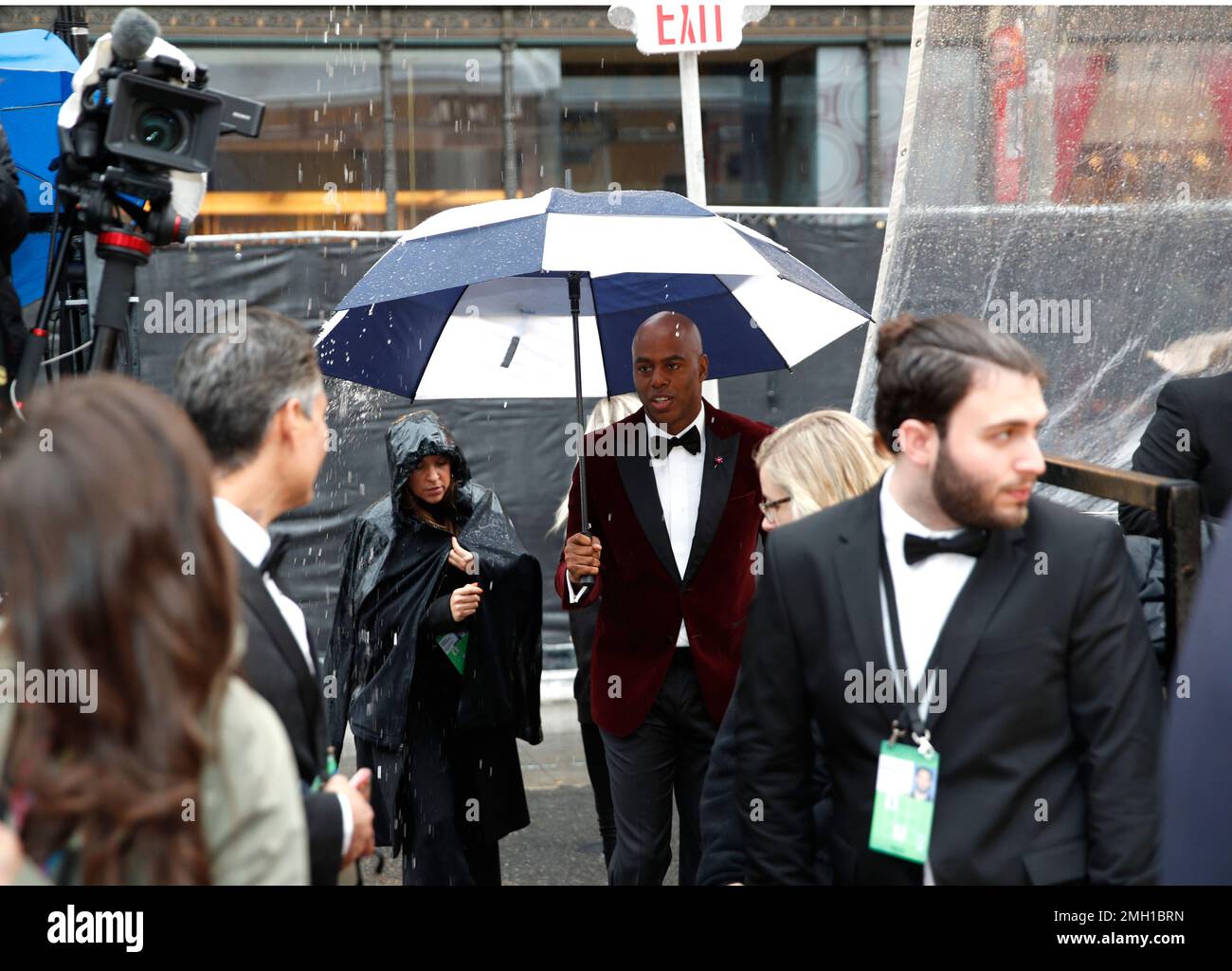 Kevin Frazier carries an umbrella on the red carpet at the Oscars on ...