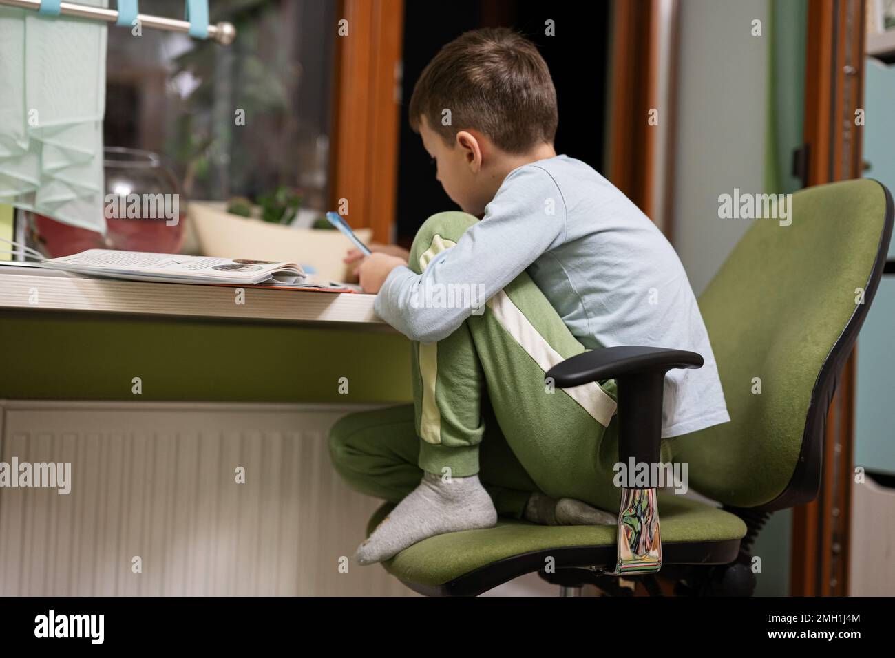 Kid boy studying at home and doing school homework, distance learning ...