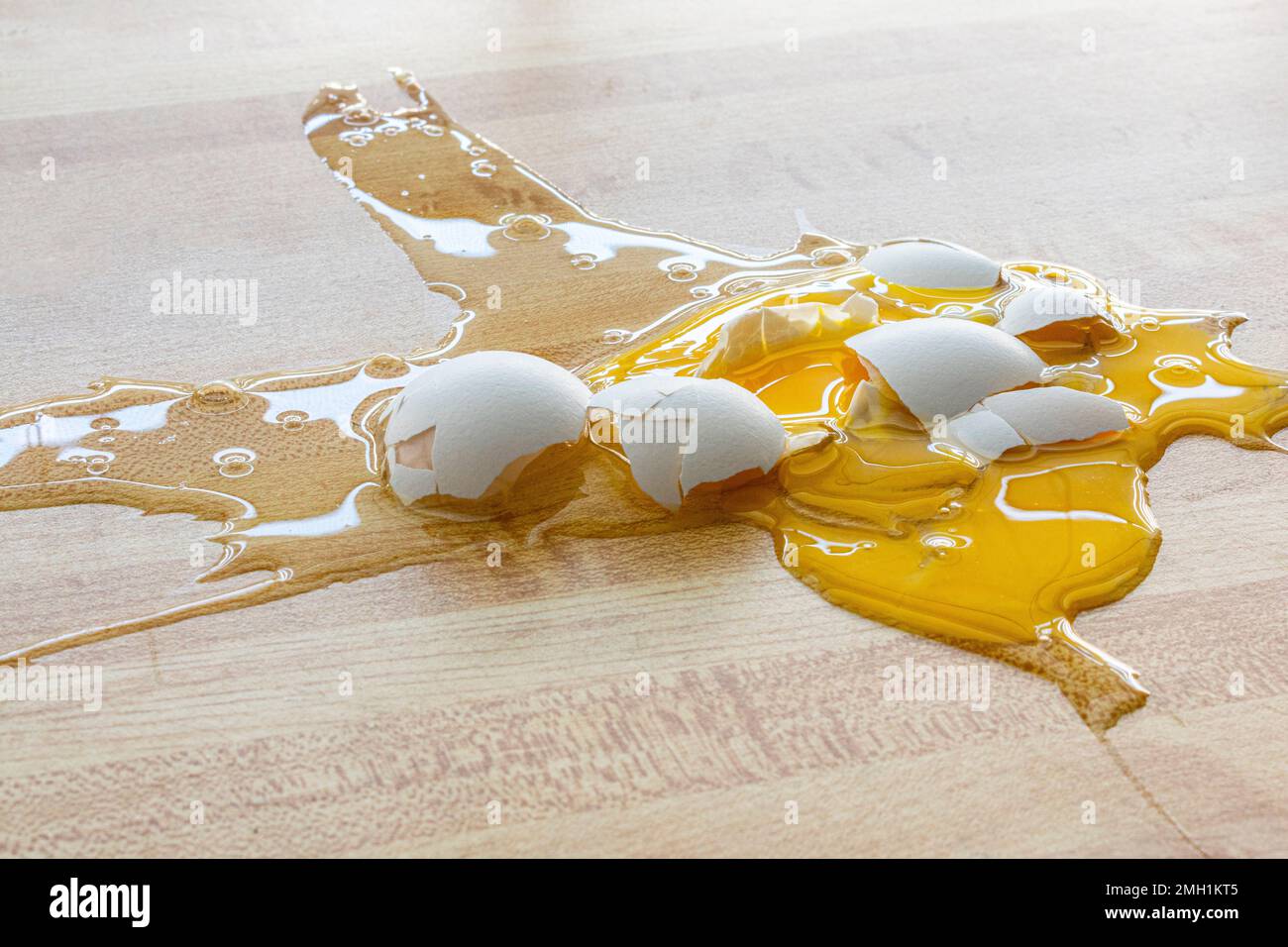 Horizontal shot of a white chicken egg on the floor making a mess Stock ...