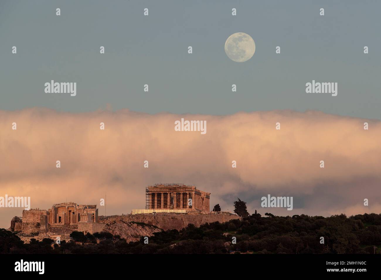 The moon rises behind the ancient Acropolis hill with the 500 BC ...