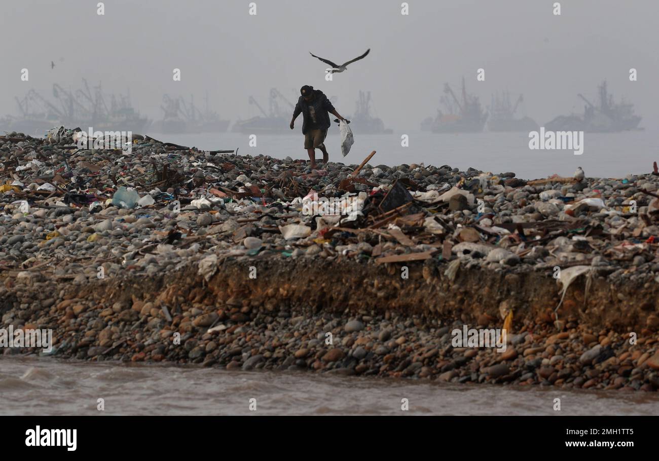 A man walks on garbage that accumulates along the banks of the Chillon ...