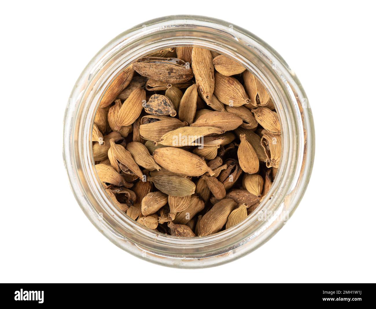 Old dry cardamom pods in a glass jar on a white background. Cardamom is ...