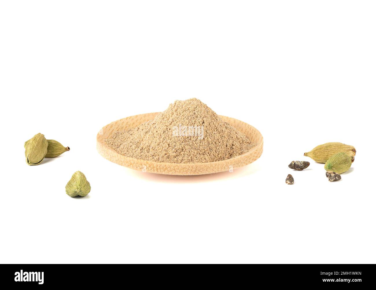 Ground cardamom on a wooden bowl and pods with cardamom seeds on a ...