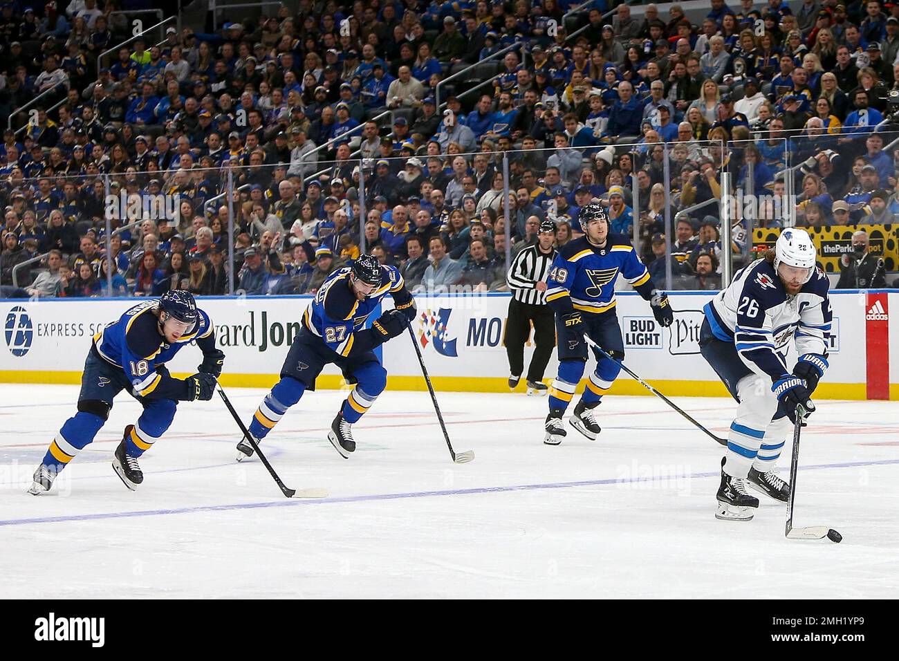 Winnipeg Jets' Blake Wheeler (26) skates with the puck ahead of three ...