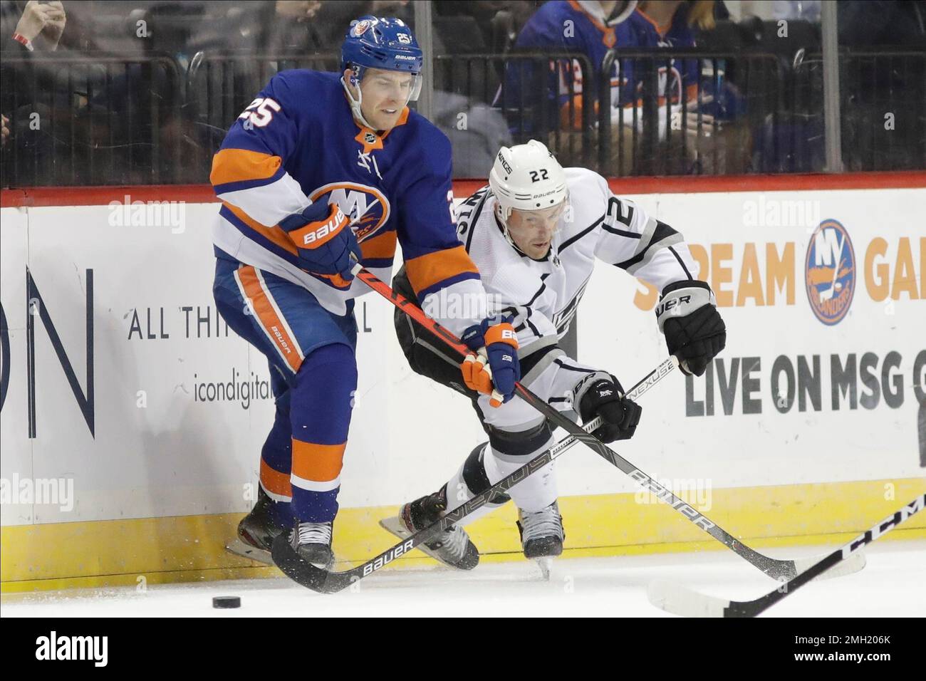 New York Islanders' Devon Toews (25) fights for control of the puck ...