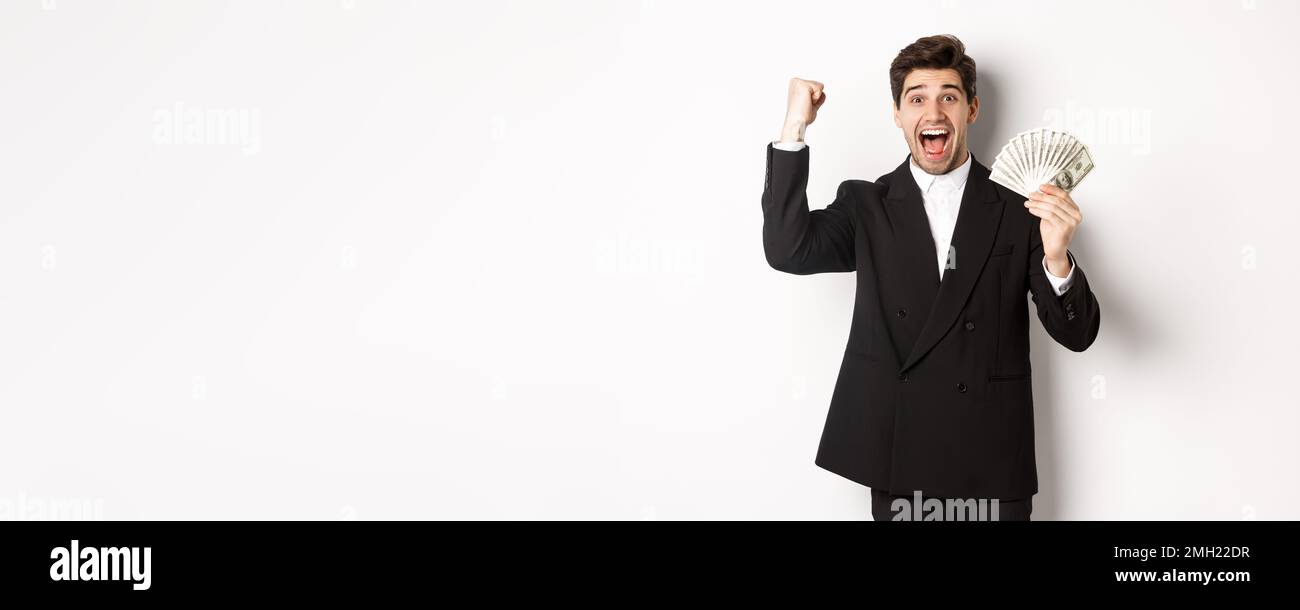 Portrait of handsome businessman in black suit, winning money and ...