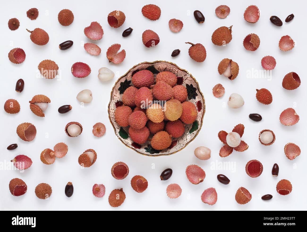 Lychee fruit in bowl on white background with scattered whole and ...