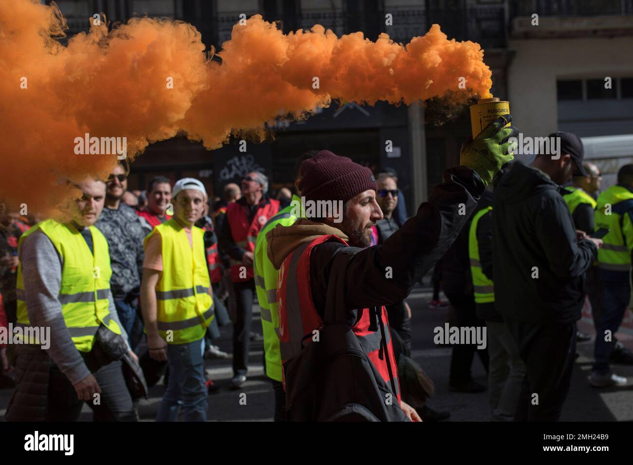 A striking dock worker holds up a smoke canister during a demonstration ...