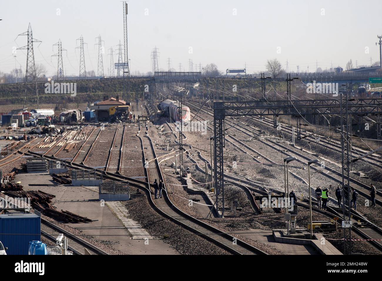 Police inspect tracks at a switch point, bottom right, as a derailed ...