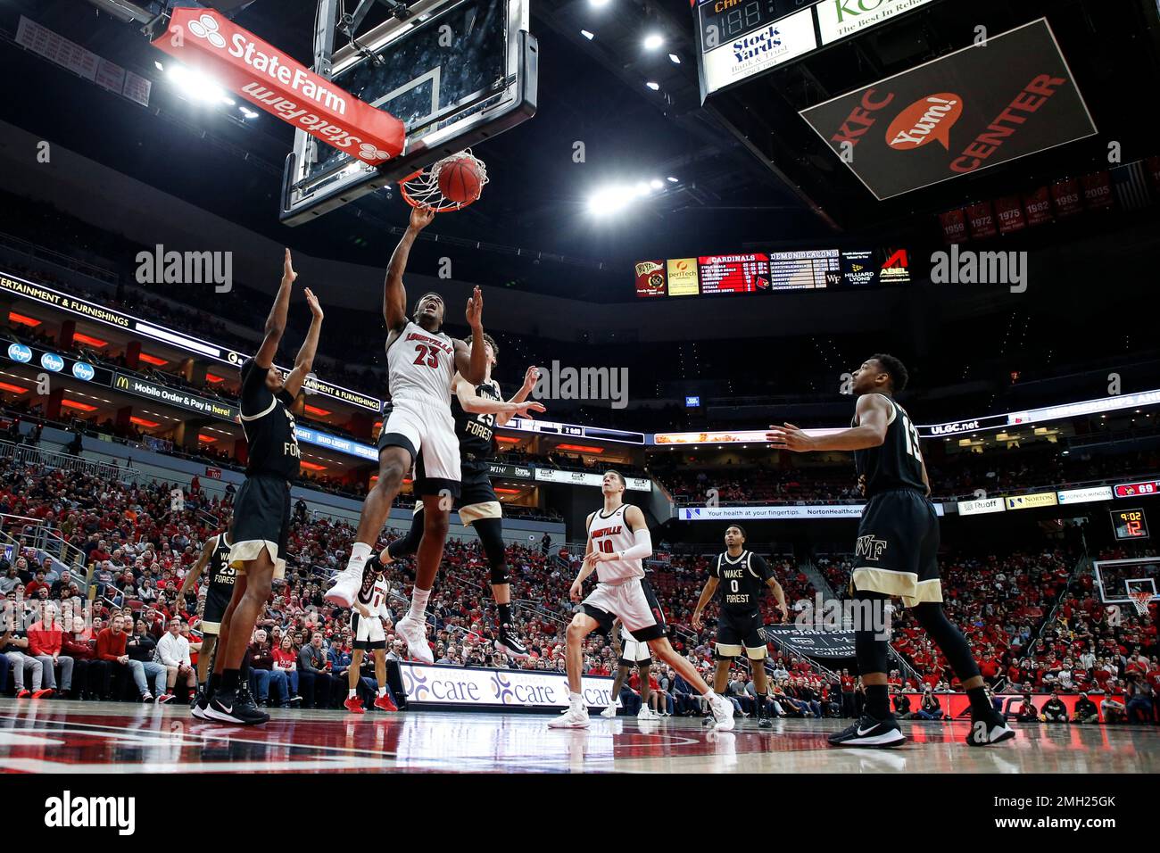 Louisville center Steven Enoch (23) dunks next to Wake Forest forward ...