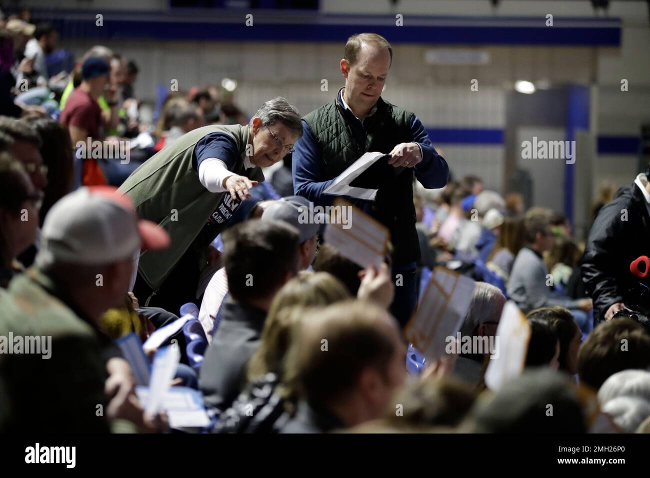 Precinct 68 Iowa Caucus voters seated in the Biden section hold up ...