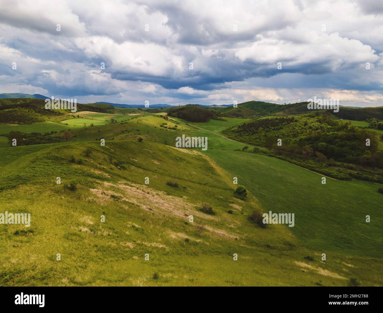 Aerial photo of a landscape bordered by hills and forests, with an ...
