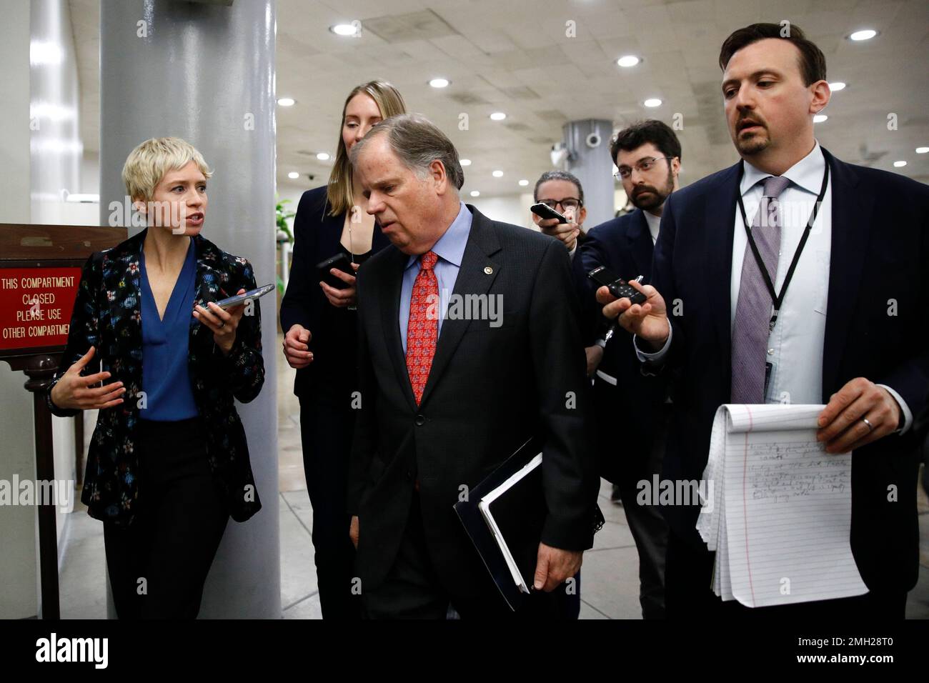 Sen. Doug Jones, D-Ala., center, speaks with reporters on Capitol Hill ...