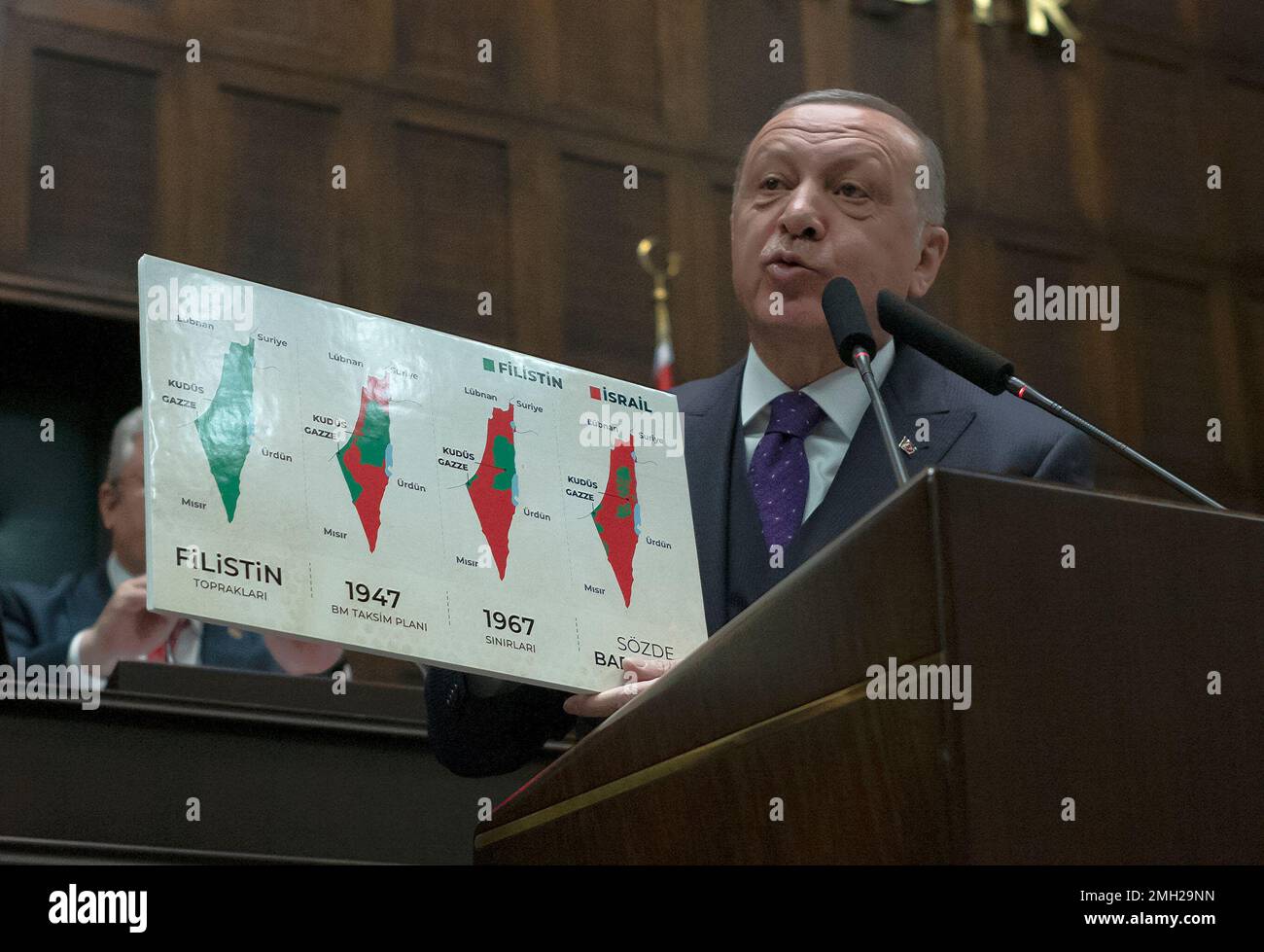 Turkey's President Recep Tayyip Erdogan holds up a placard with what he ...